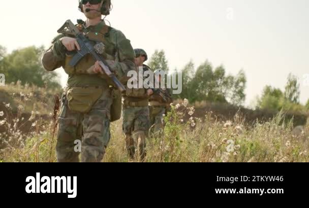 young soldiers are holding guns, protecting area, territory, slow ...