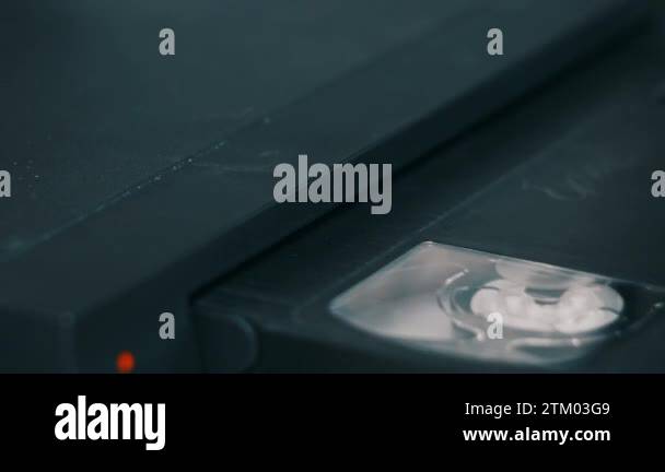 Insert VHS cassette into VCR player. Black vintage videotape cassette ...