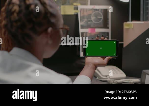 Police officer using greenscreen in evidence room, showing mockup ...