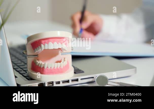 Oral dental. Dentist doctor in uniform writing information of patient ...