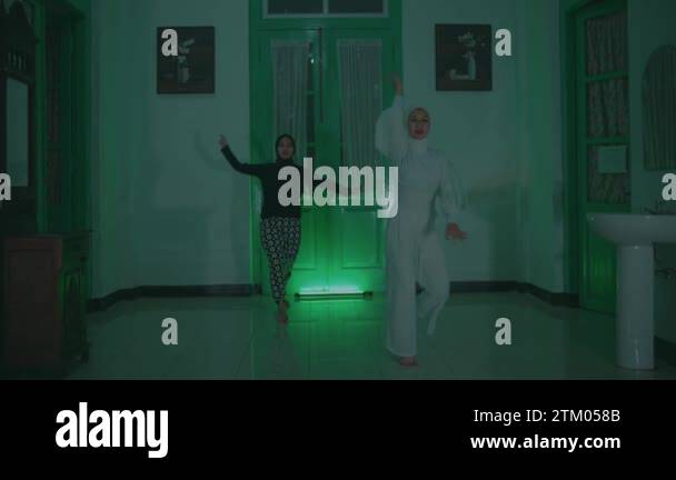 two Muslim women dance together very agilely in closed clothes in a ...