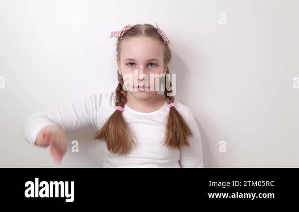 little girl with a raised hand making a stop sign gesture on a black ...