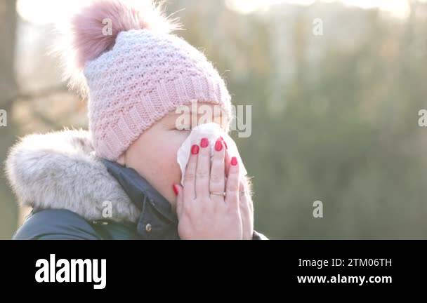 Young woman sneezing in the tissue, blowing runny nose with symptoms ...