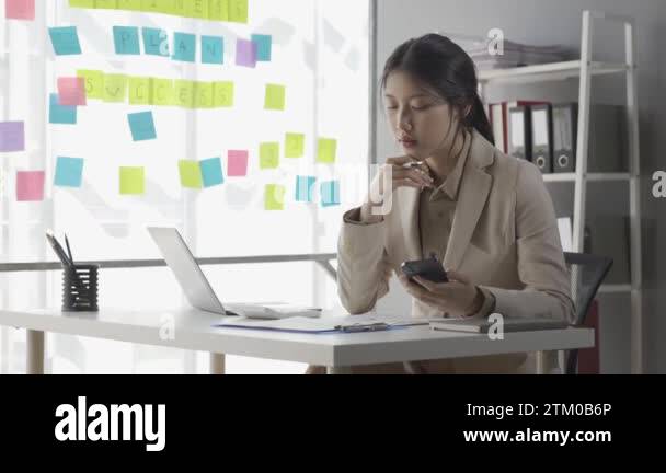 Beautiful young Asian accountant using calculator to calculate savings ...