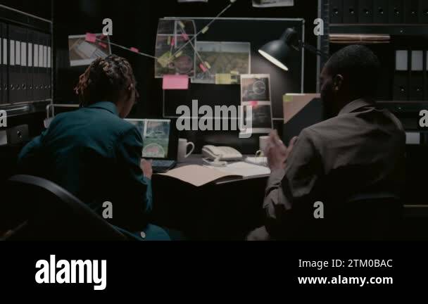 African American Agents Examining Surveillance Photos Working On