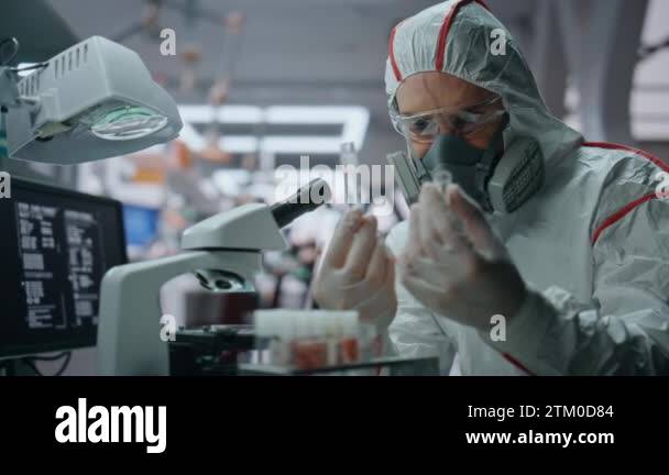 Lab chemist working at experimental laboratory in safety suit close up ...