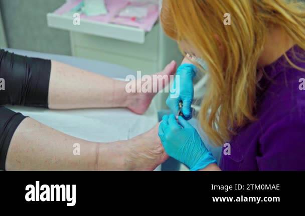 Close-up of a womans feet having a pedicure performed. A podiatrist ...