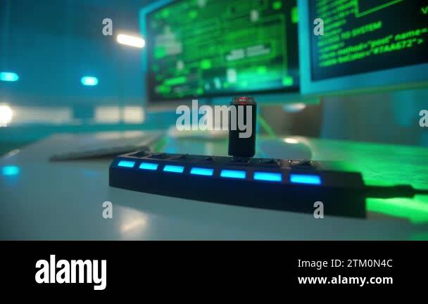 A black flash drive with a red flashing light is inserted into the USB ...