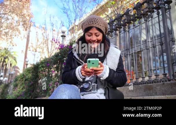 Young asian woman using a cellphone app for texting messages in a ...