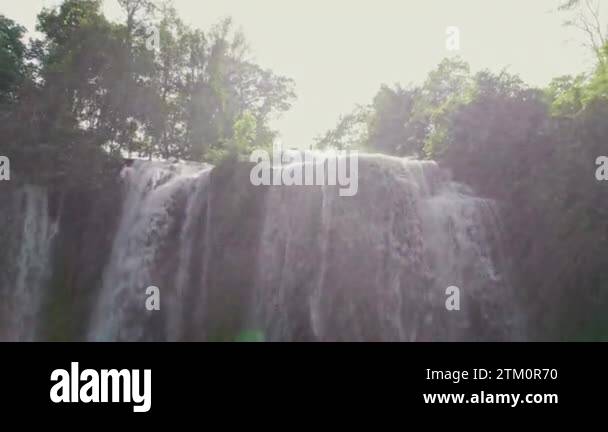Receding shot showing the Phnom Kulen waterfall splashing on the view ...