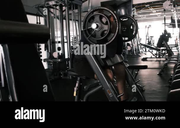 Barbell bench press. A young athlete on a simulator in a supine ...