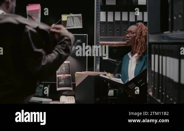 Detective inspectors doing background checks in archive, examining ...
