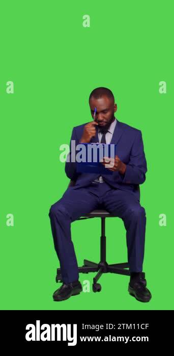 Vertical video: Front view of african american businessman taking notes ...