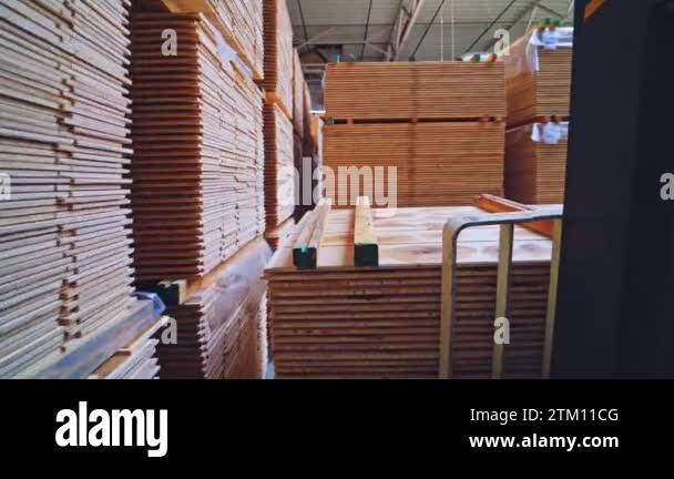 Wooden boards for flooring in the factory. Forklift cart putting pile ...