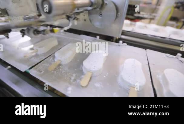 Apparatus for sorting ice cream. Ice cream dosing machine on a conveyor ...