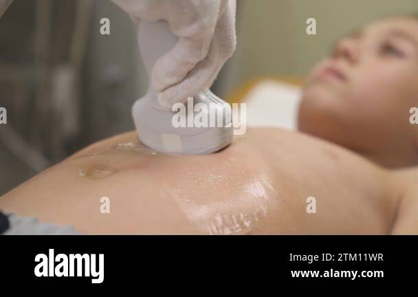Little boy undergoing ultrasound scan in modern clinic. Focus on ...