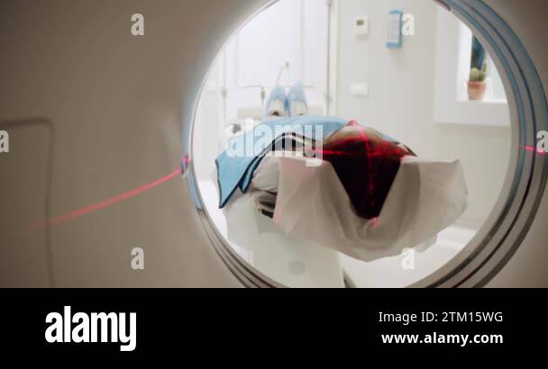 Female patient lying on computed tomography and moving inside machine ...