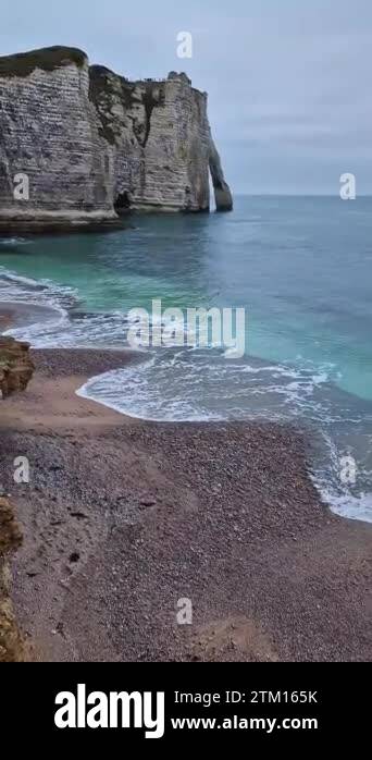 Sightseeing vertical view to the wonderful cliffs of Etretat washed by ...