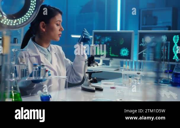 A Korean female doctor applies a sample of red liquid with a pipette ...