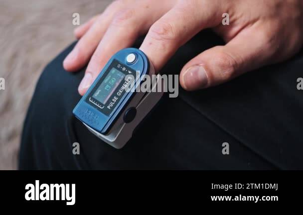 Pulse oximeter measures pulse and oxygen saturation on a male finger ...