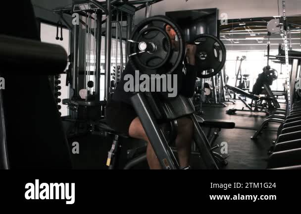 Barbell bench press. A young athlete on a simulator in a supine ...