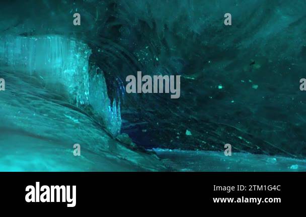 Turquoise pure color of ice inside the ice cave. Stones and icicles are ...