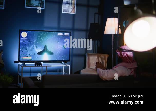 Arab gamer playing classic arcade space shooter videogame, shooting ...