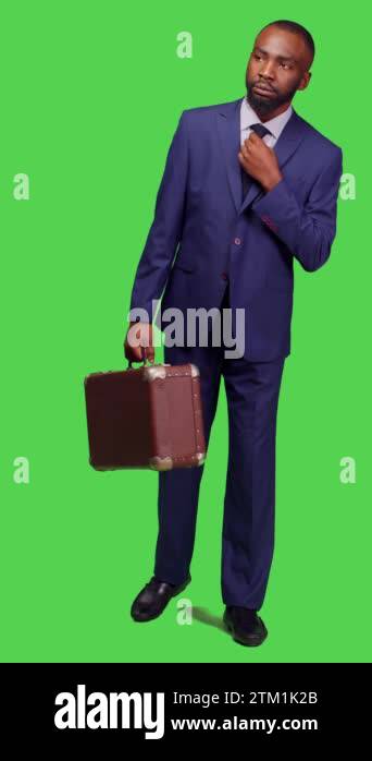 Vertical video: Front view of corporate worker carrying suitcase at ...