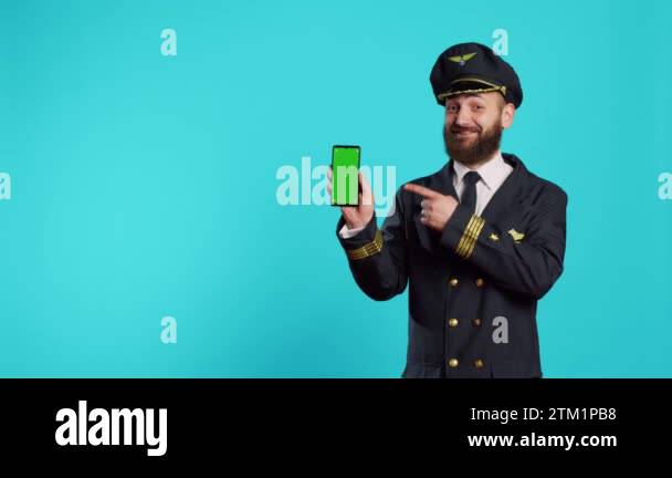 Positive aircrew captain showing phone with greenscreen, holding ...