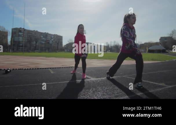 Young girls spend training exercises before the race. leg muscle warm ...