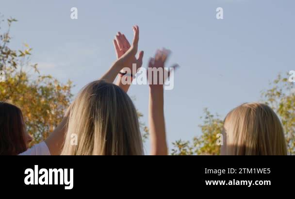 Teenager girls raise hands to sky demonstrating strong connection and ...
