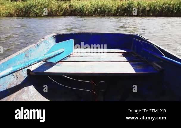an old boat in the lake is carried away by the current against the ...