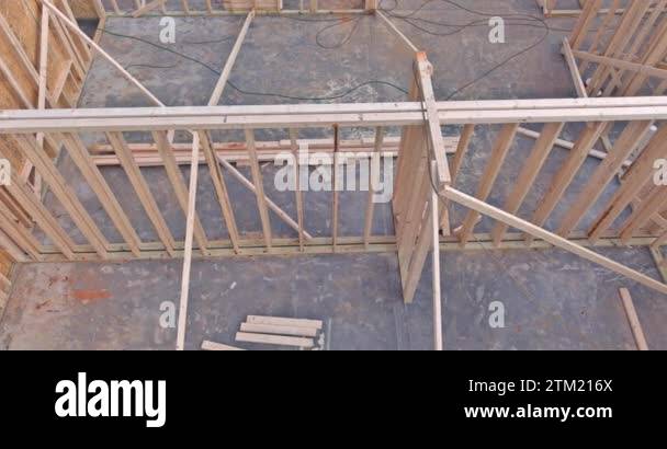 Construction of stick house involves assembling timber beams into truss ...