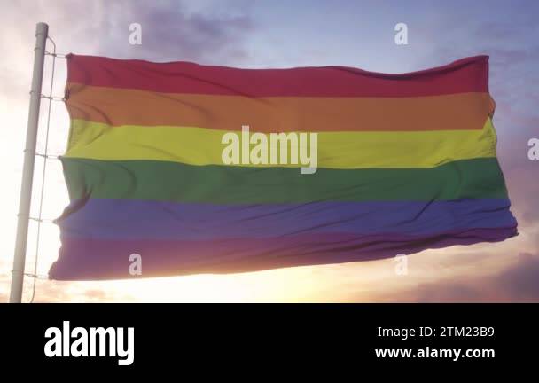 LGBT flag waving in the wind, sky and sun background. LGBT Rainbow Flag ...
