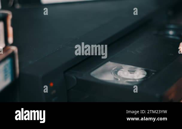 Insert VHS cassette into VCR player. Black vintage videotape cassette ...