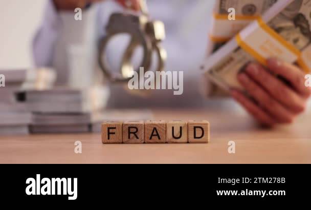 Person holding dollar bills in handcuffs and word fraud. Problem of ...