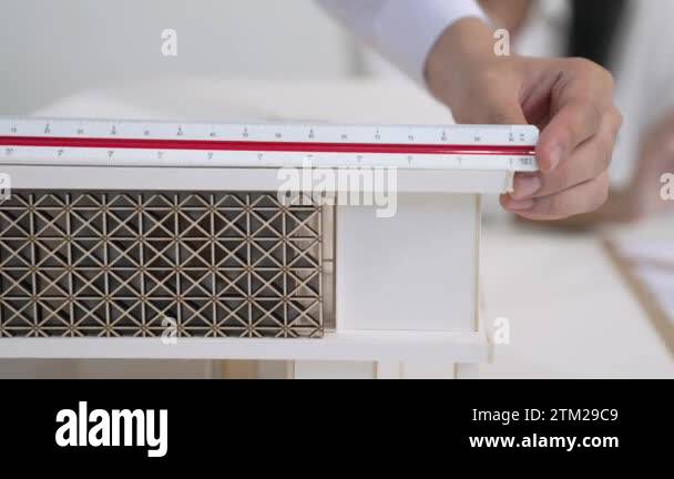 Professional male engineer measure house model by using ruler while ...