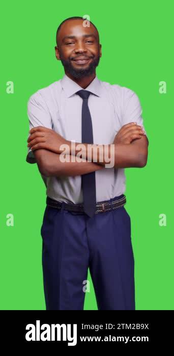 Vertical video: Front view of young businessman posing on greenscreen ...