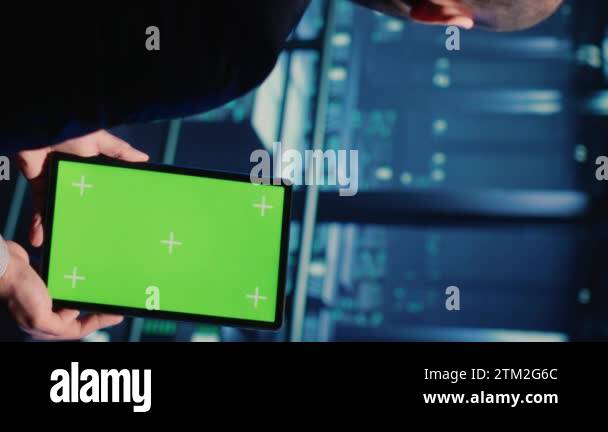 Vertical video: Network engineer doing system check on green screen ...