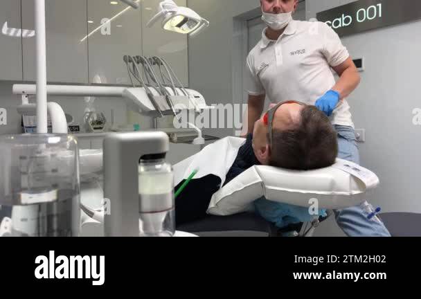 young doctor hopping sits near patient Cheerful inept doctor wearing ...