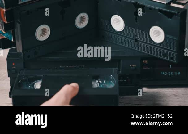 Insert VHS cassette into VCR player. Black vintage videotape cassette ...