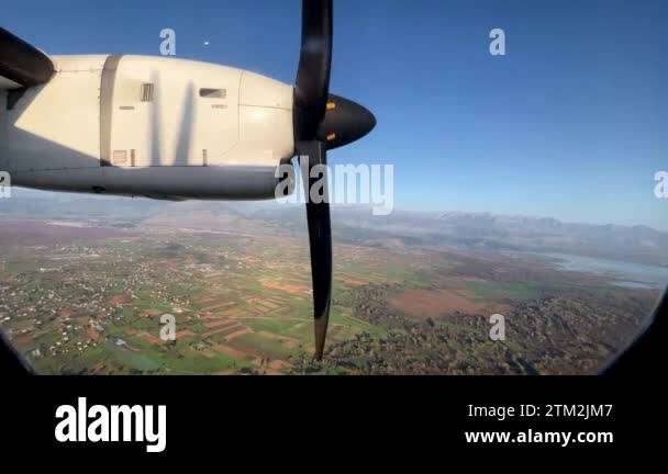 Rotating propeller of an airplane flying above the ground. Porthole ...
