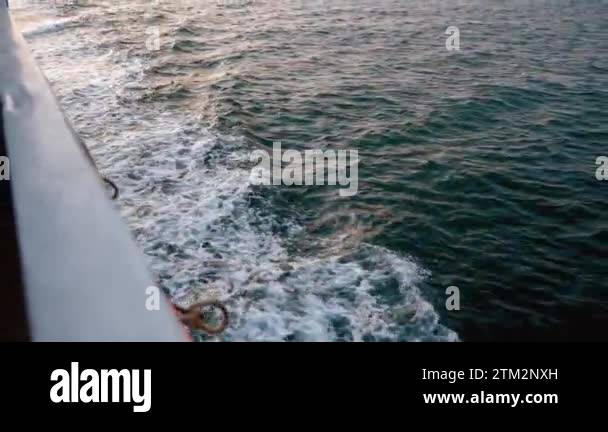 Top view of deck and side of wooden boat sailing on sea. Ship cuts ...
