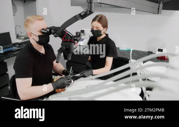 At the dental clinic a dentist examines a patient with toothache under ...