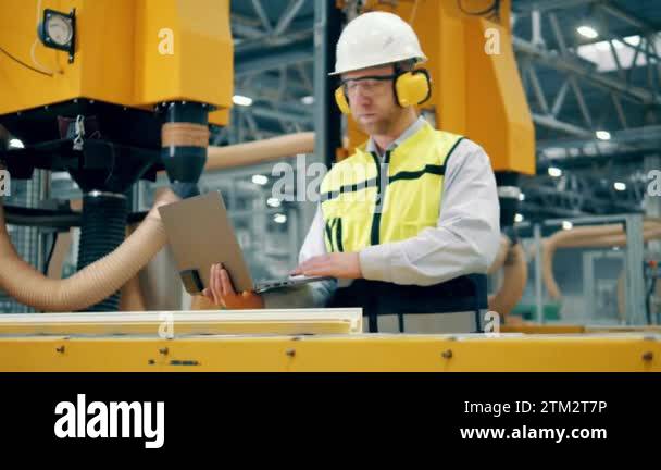 Factory employee is observing a fiberglass bar on the conveyor. 4K ...