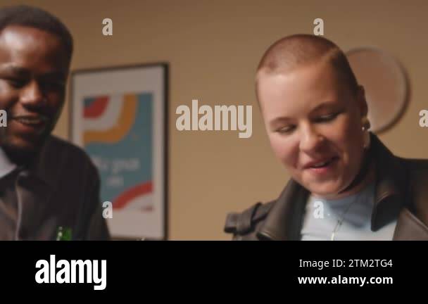 Group of cheerful multiethnic young people playing drinking games with ...