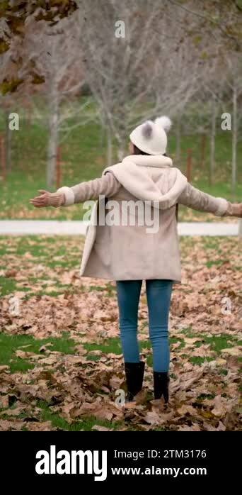 Preteen girl play spinning while autumn leaves are falling over her ...