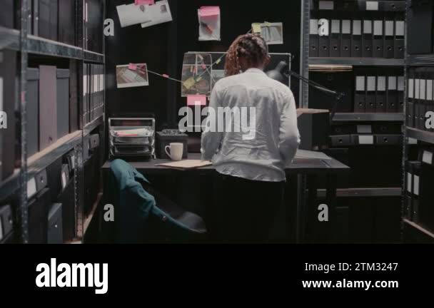 Female inspector reading crime case file in archive, trying to conduct ...