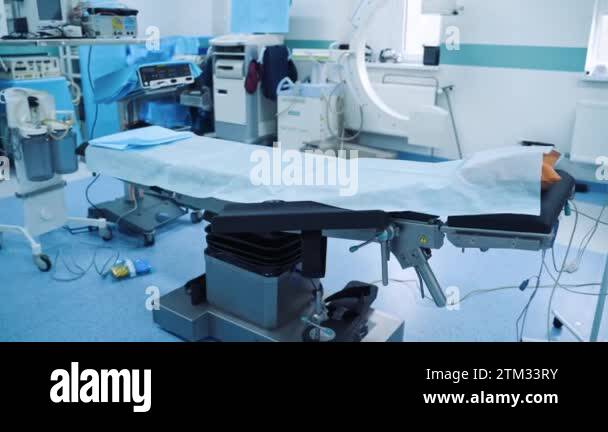 Surgery room with modern equipment. Surgical bed in the centre of the ...
