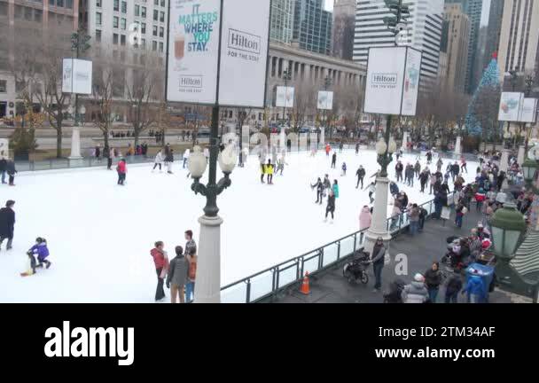 People skating on an outdoor ice rink in downtown Chicago on cloudy ...